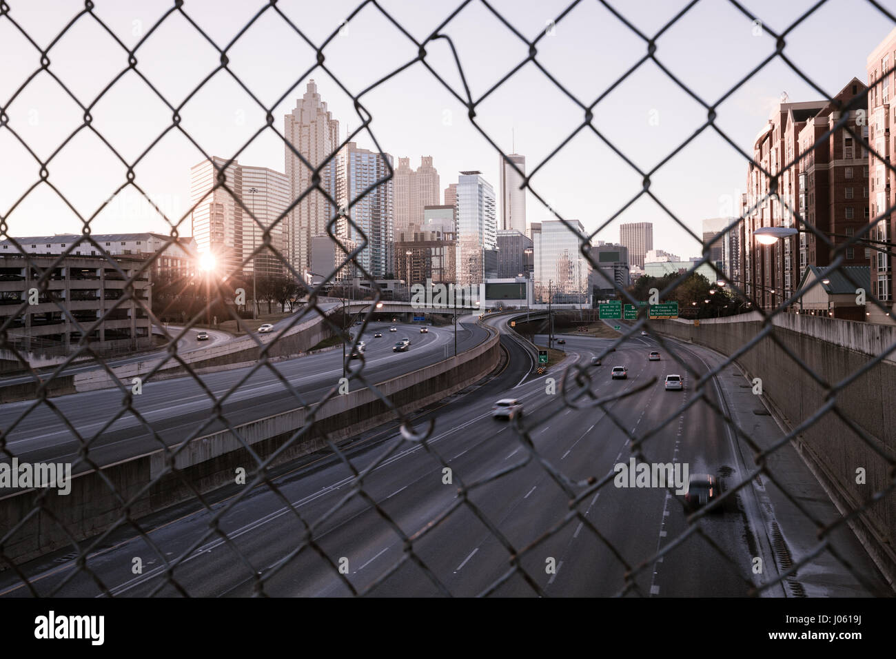 Morning city skyline through the wire mesh fence. Sunrise Atlanta ...