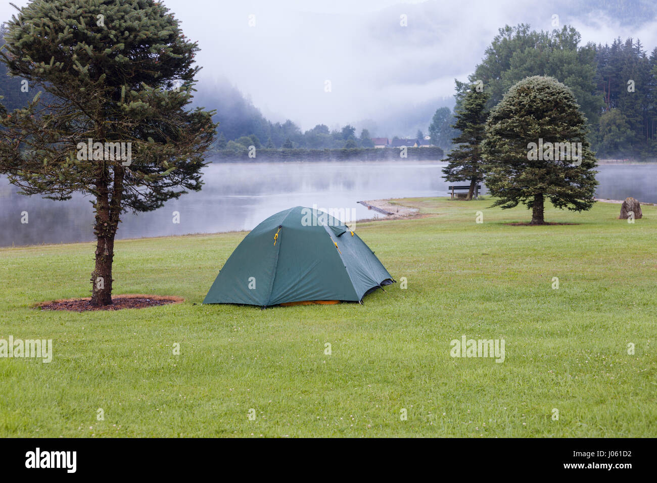 Camping tent on green grass lawn near the lake Stock Photo - Alamy
