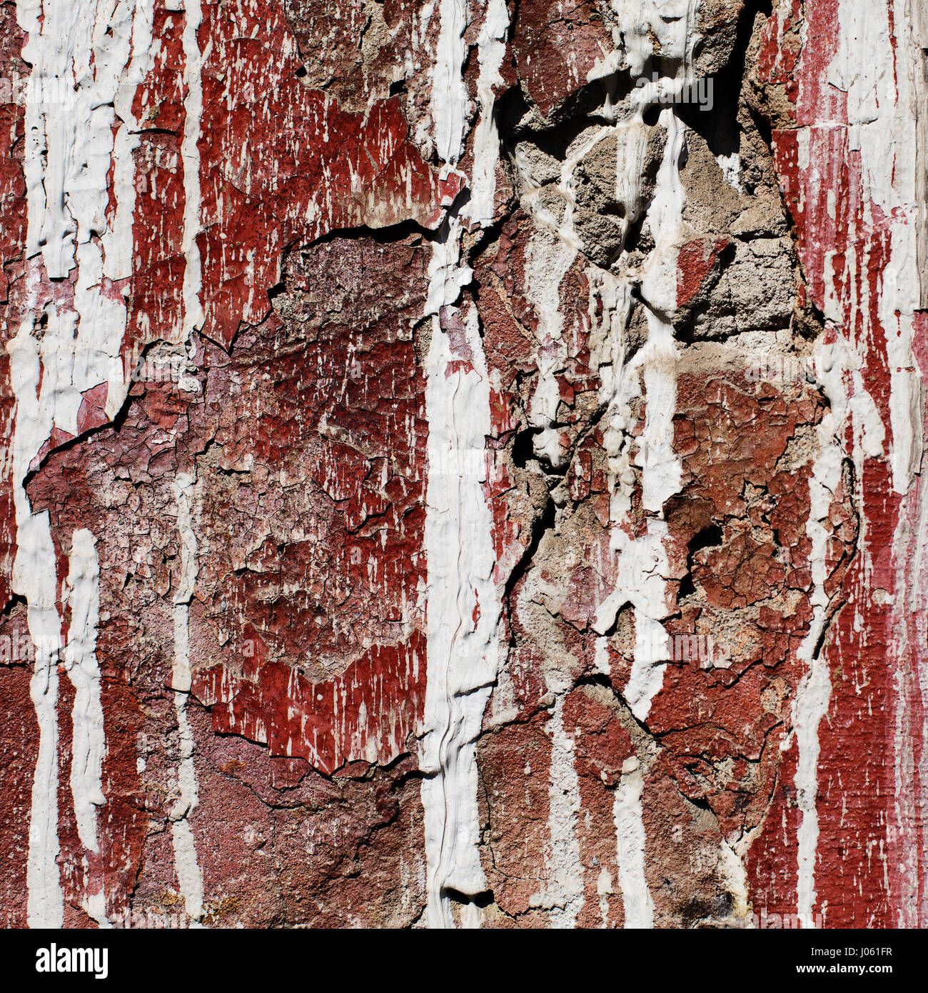 Old damaged wall painted with red and white colors, inner structure ...