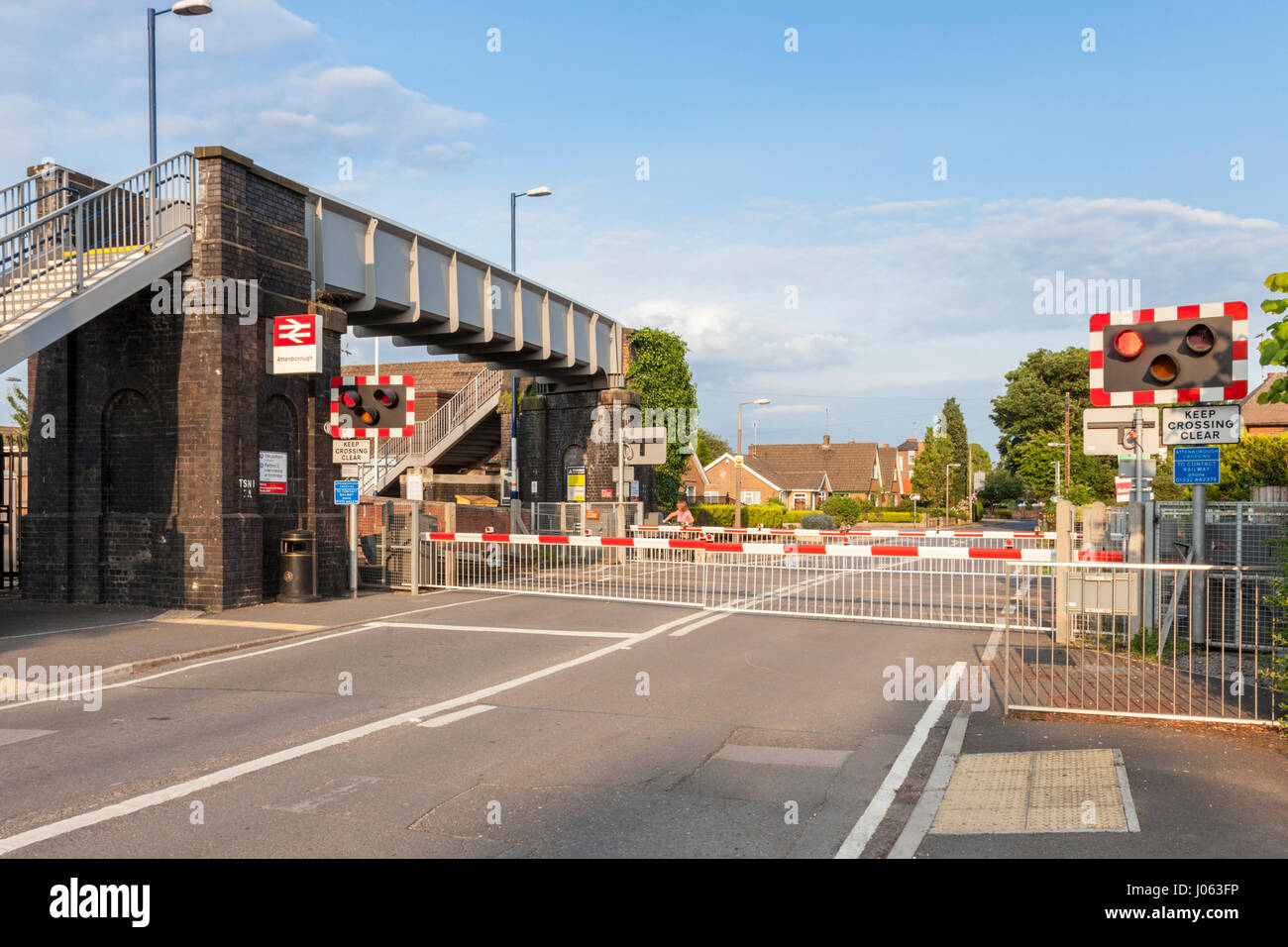 Road with level crossing barriers lowered, Attenborough Railway Station ...