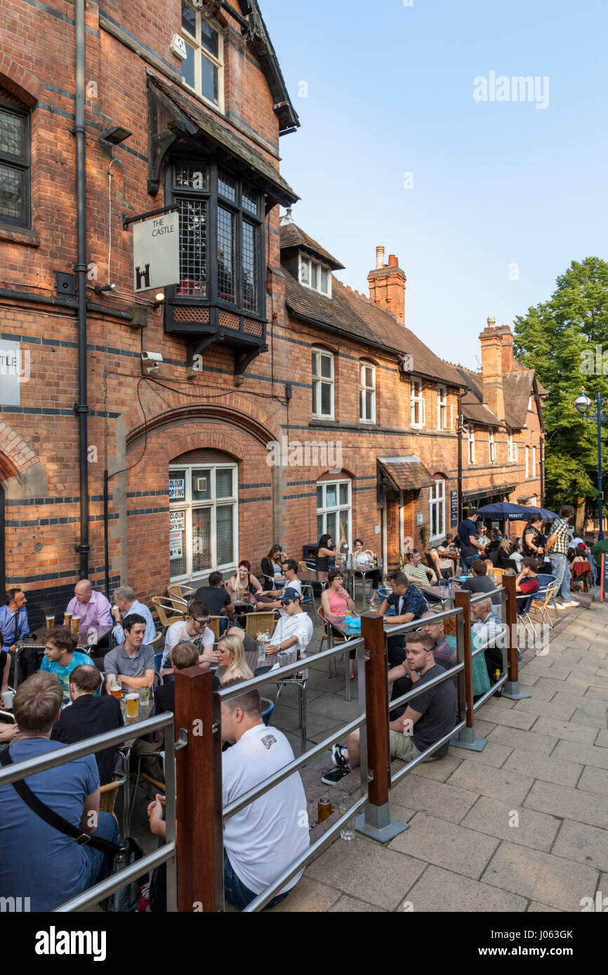 People sitting and drinking outside a pub on a Summer evening ...