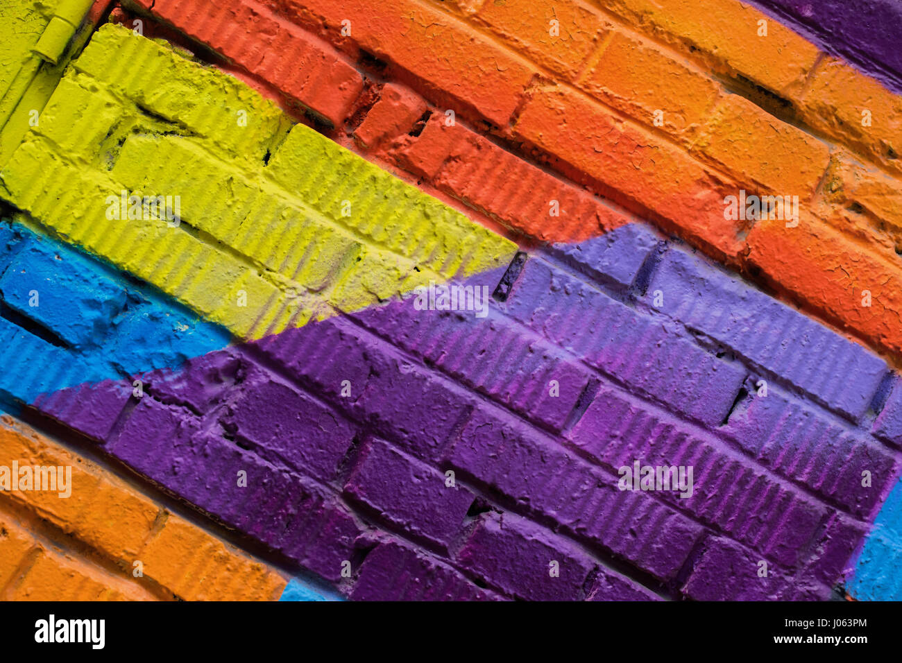 Abstract detail of brick wall with fragment of colorful graffiti ...