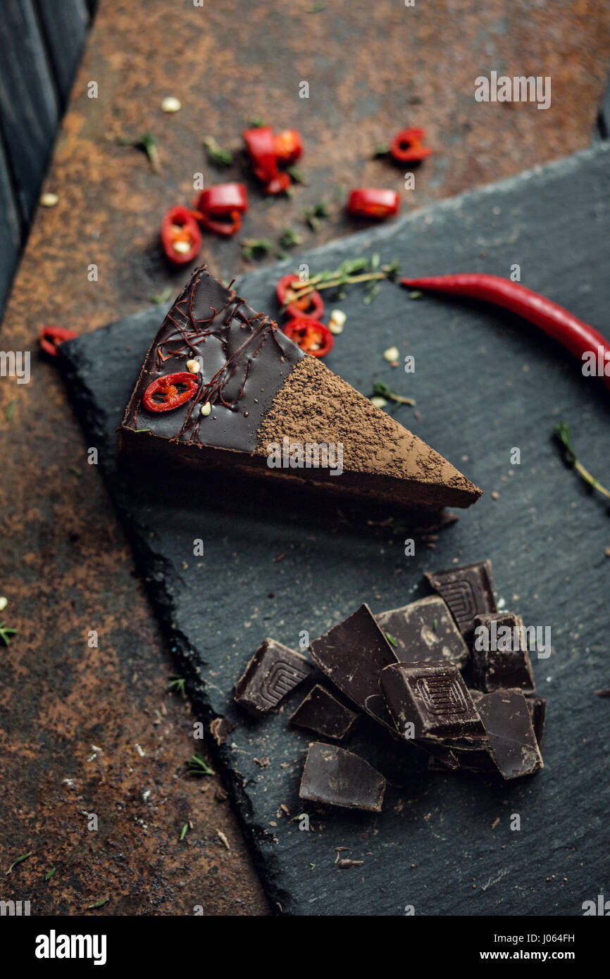 Piece of dark chocolate cake with red hot pepper. The restaurant or ...