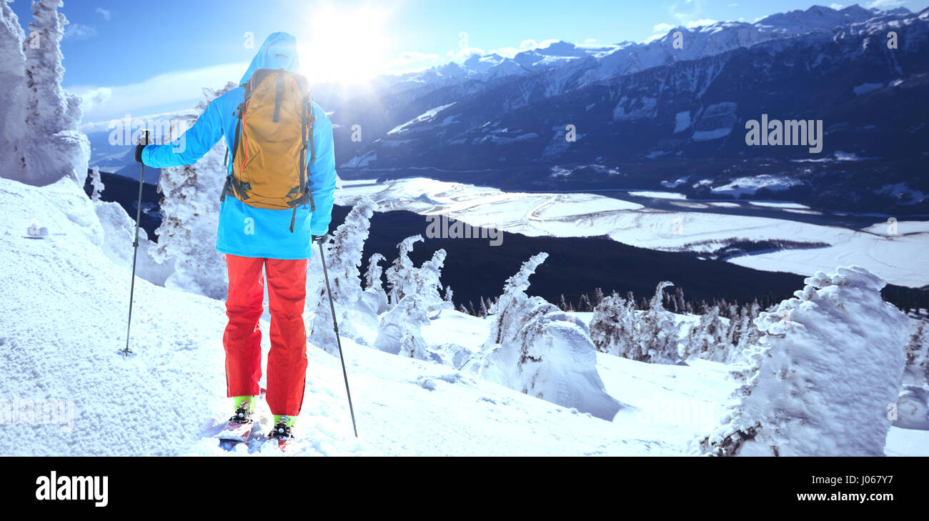 Skier with backpack on snowy field against snow covered tree on ski ...