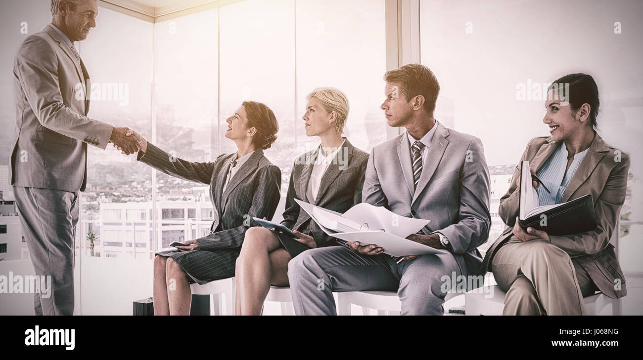 Businessman welcoming people waiting for interview in office Stock ...