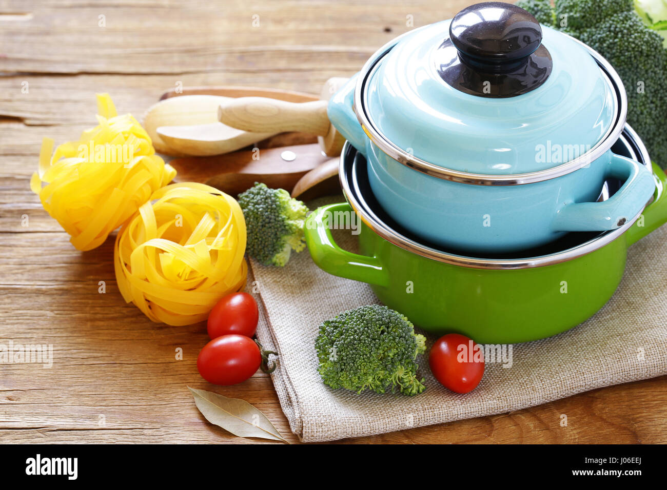 Kitchen tools - pots and cutlery on a wooden table Stock Photo - Alamy