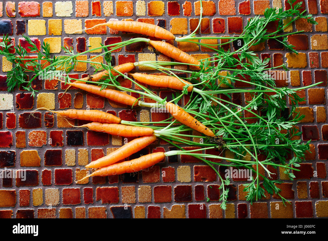 Mini Carrot vegetables on a tiles table background Stock Photo - Alamy