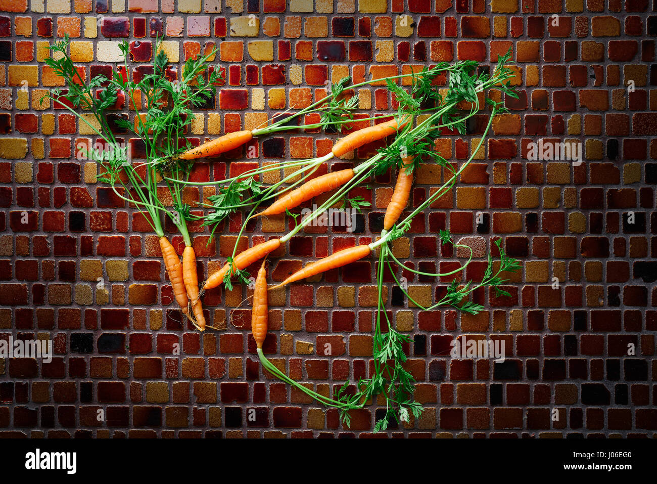 Mini Carrot vegetables on a tiles table background Stock Photo - Alamy