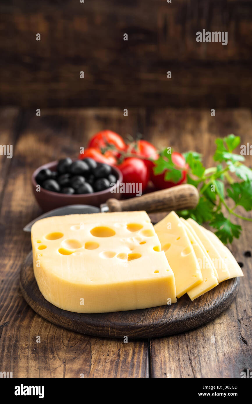 Delicious Swiss yellow cheese on dark wooden rustic background closeup ...