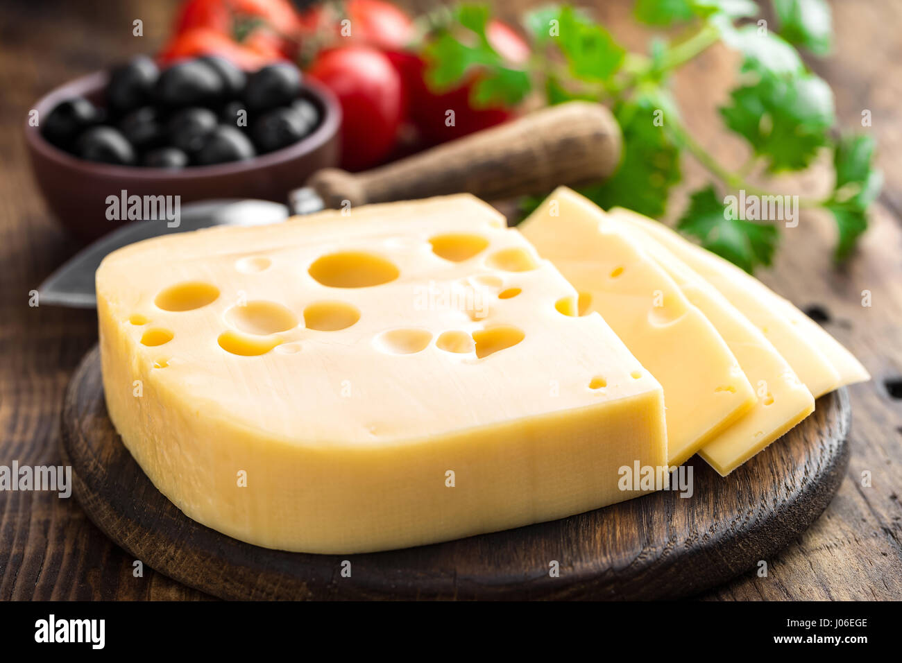 Delicious Swiss yellow cheese on dark wooden rustic background closeup ...