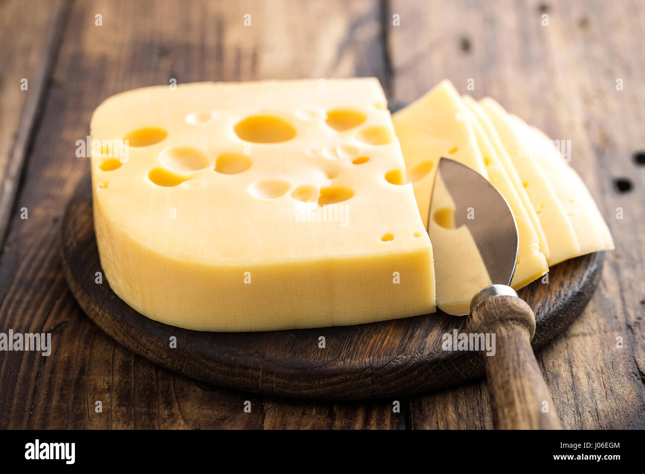 Delicious Swiss yellow cheese on dark wooden rustic background closeup ...