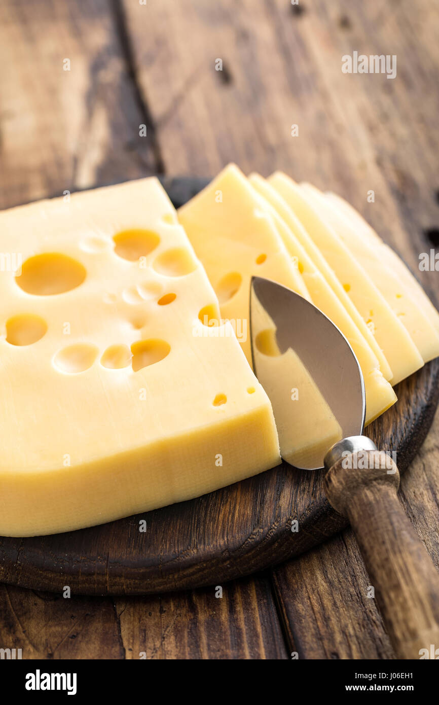 Delicious Swiss yellow cheese on dark wooden rustic background closeup ...