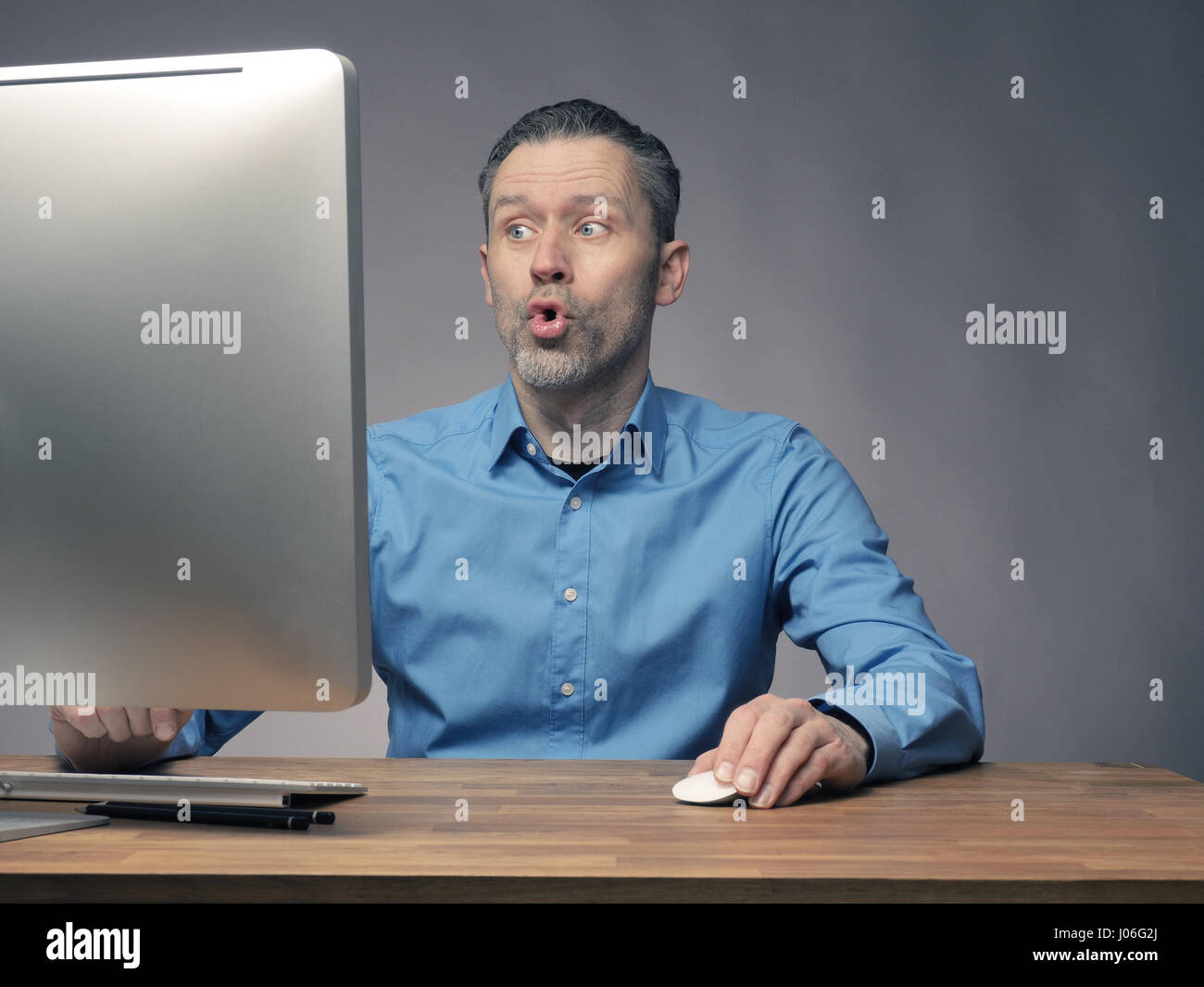 Handsome business man working on an office table with a computer Stock ...
