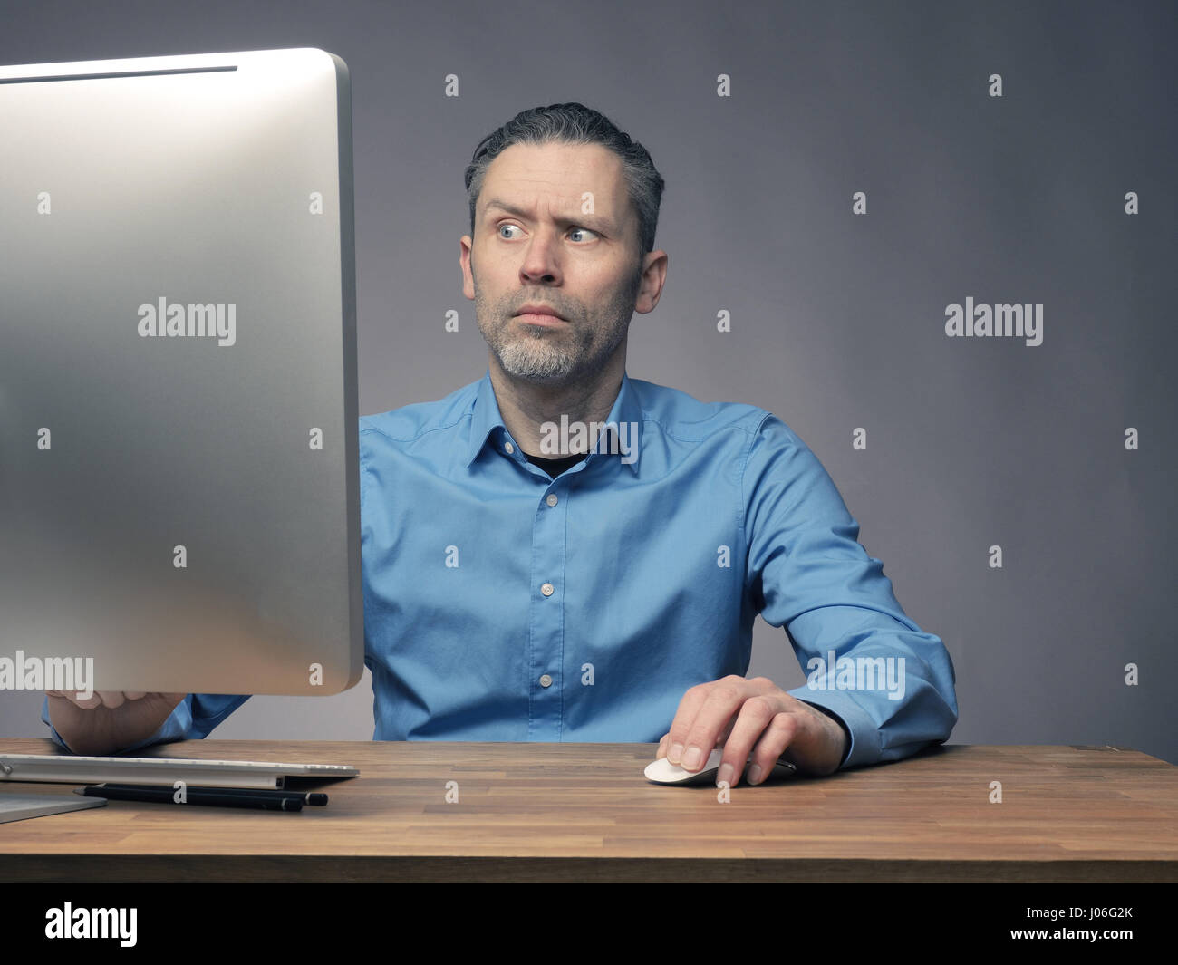 Handsome business man working on an office table with a computer Stock ...