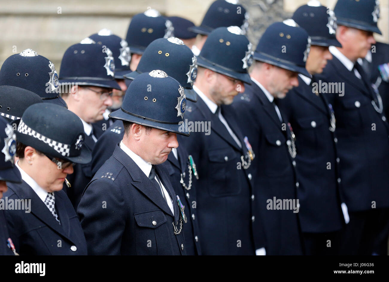 Police officers bow their heads as pall bearers carry the coffin of Pc ...