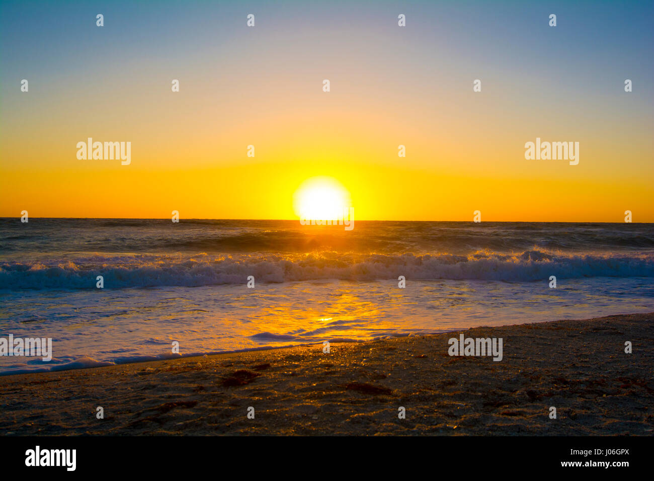 sunset over ocean beach Stock Photo - Alamy