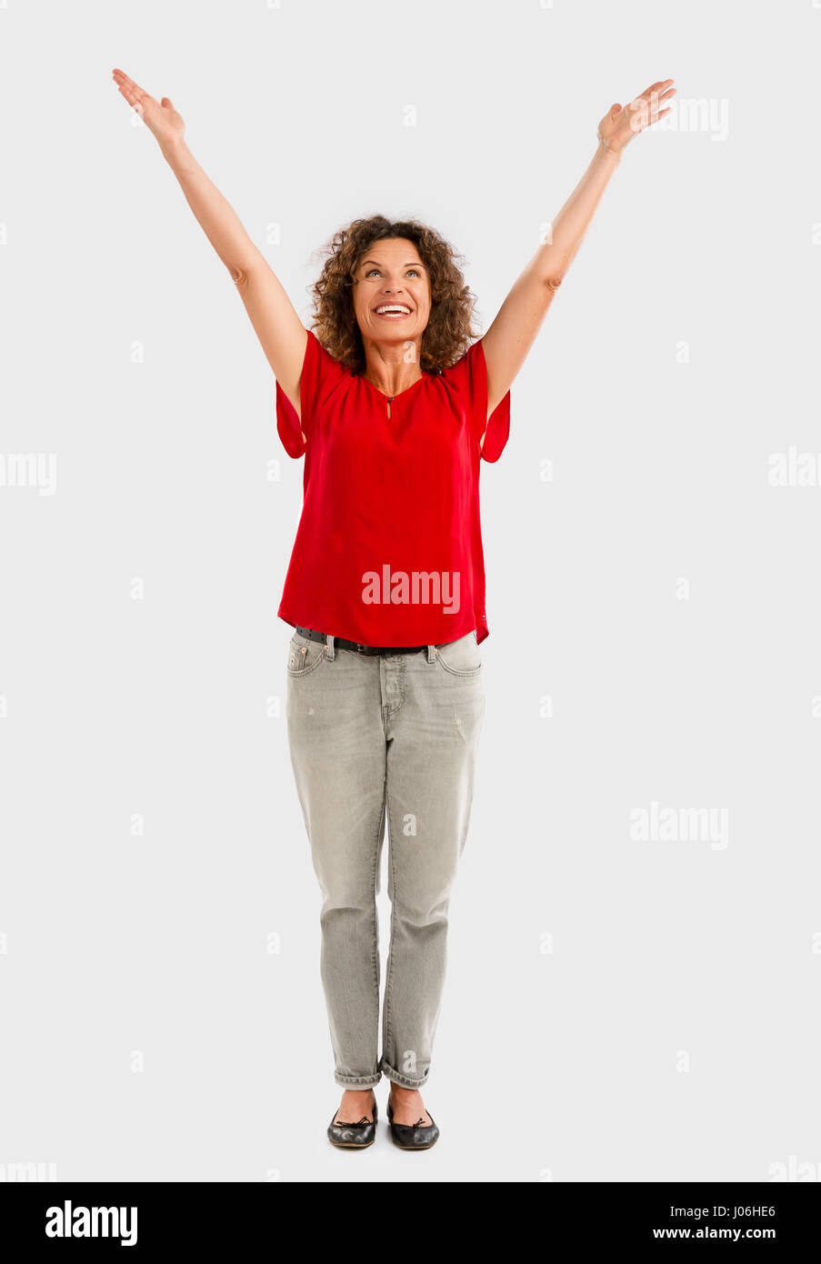Portrait of a happy middle aged brunette with arms up Stock Photo - Alamy