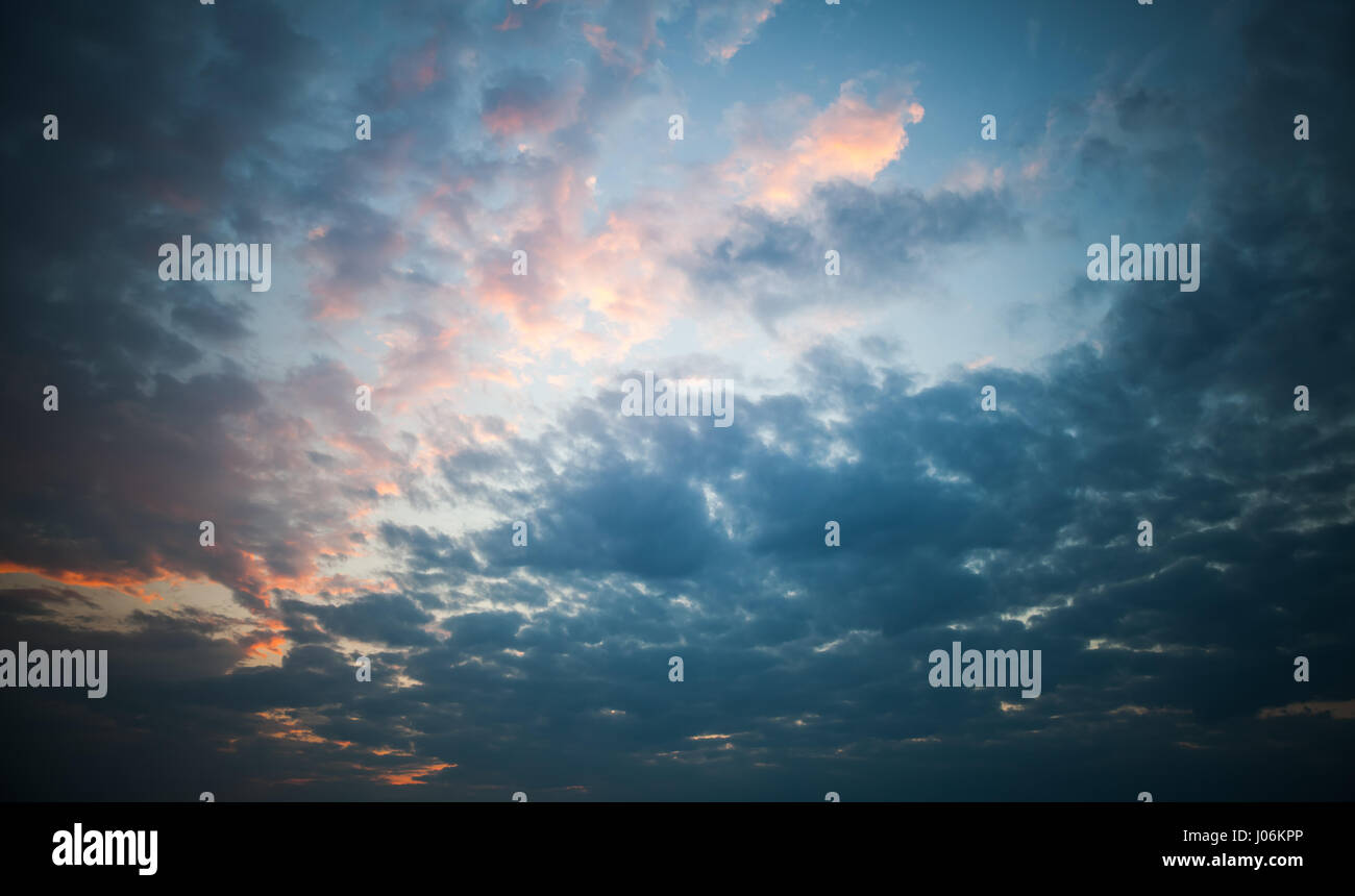 Colorful dramatic sky with dark clouds at late evening, abstract nature ...