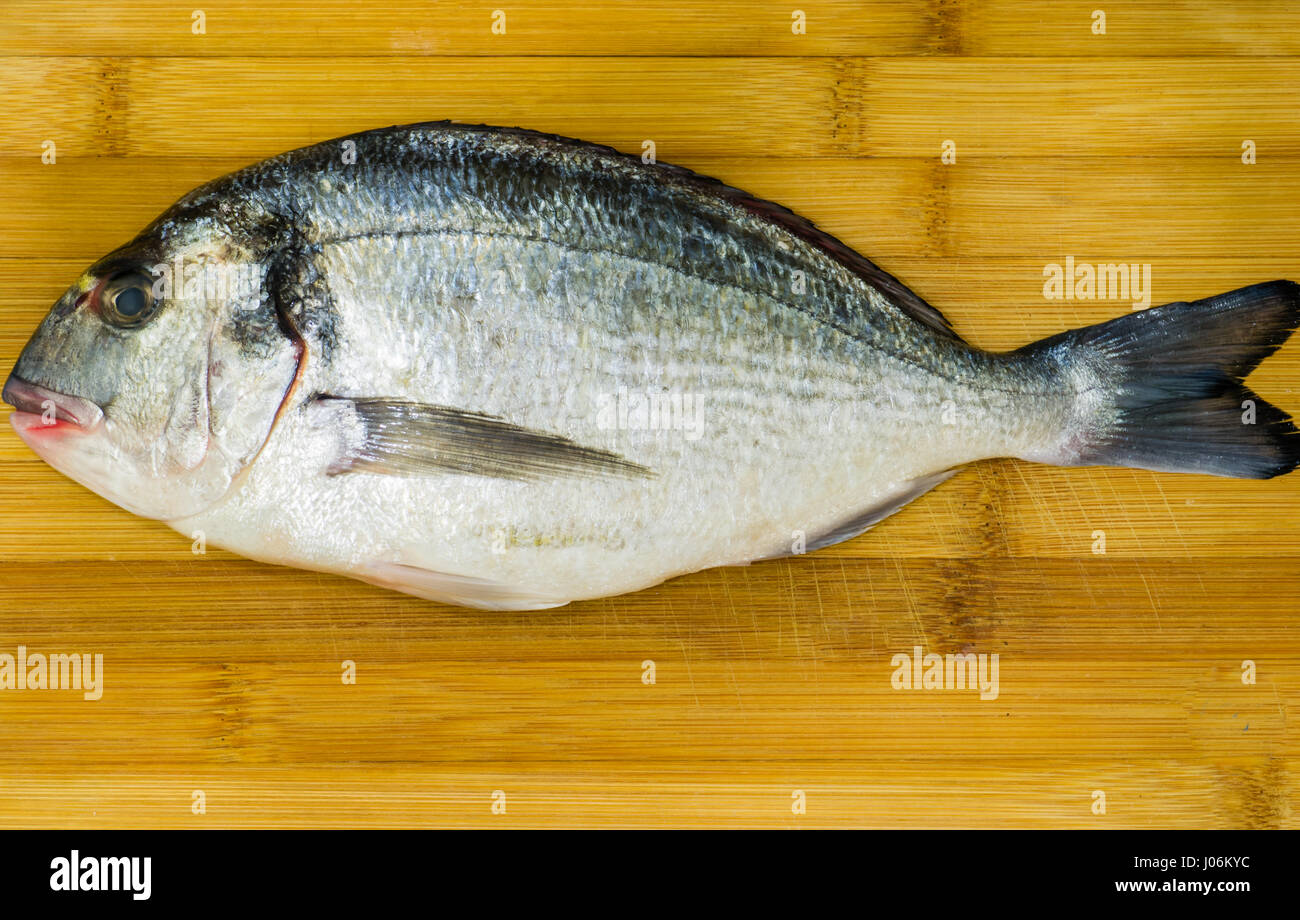 fish delicacy on wooden background with lemon Stock Photo - Alamy