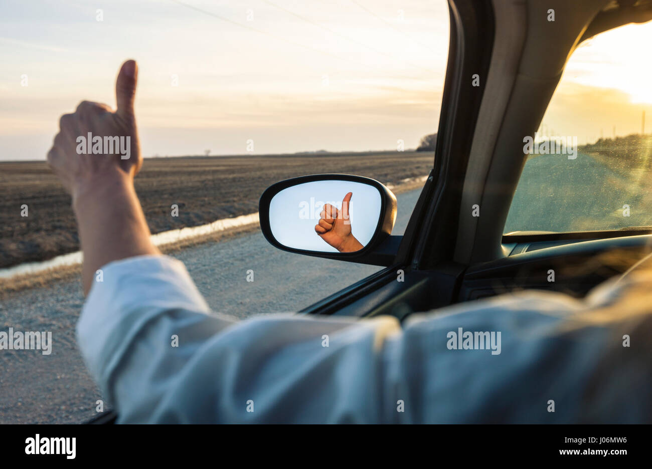 Woman hand showing hitchhike from open window Stock Photo - Alamy
