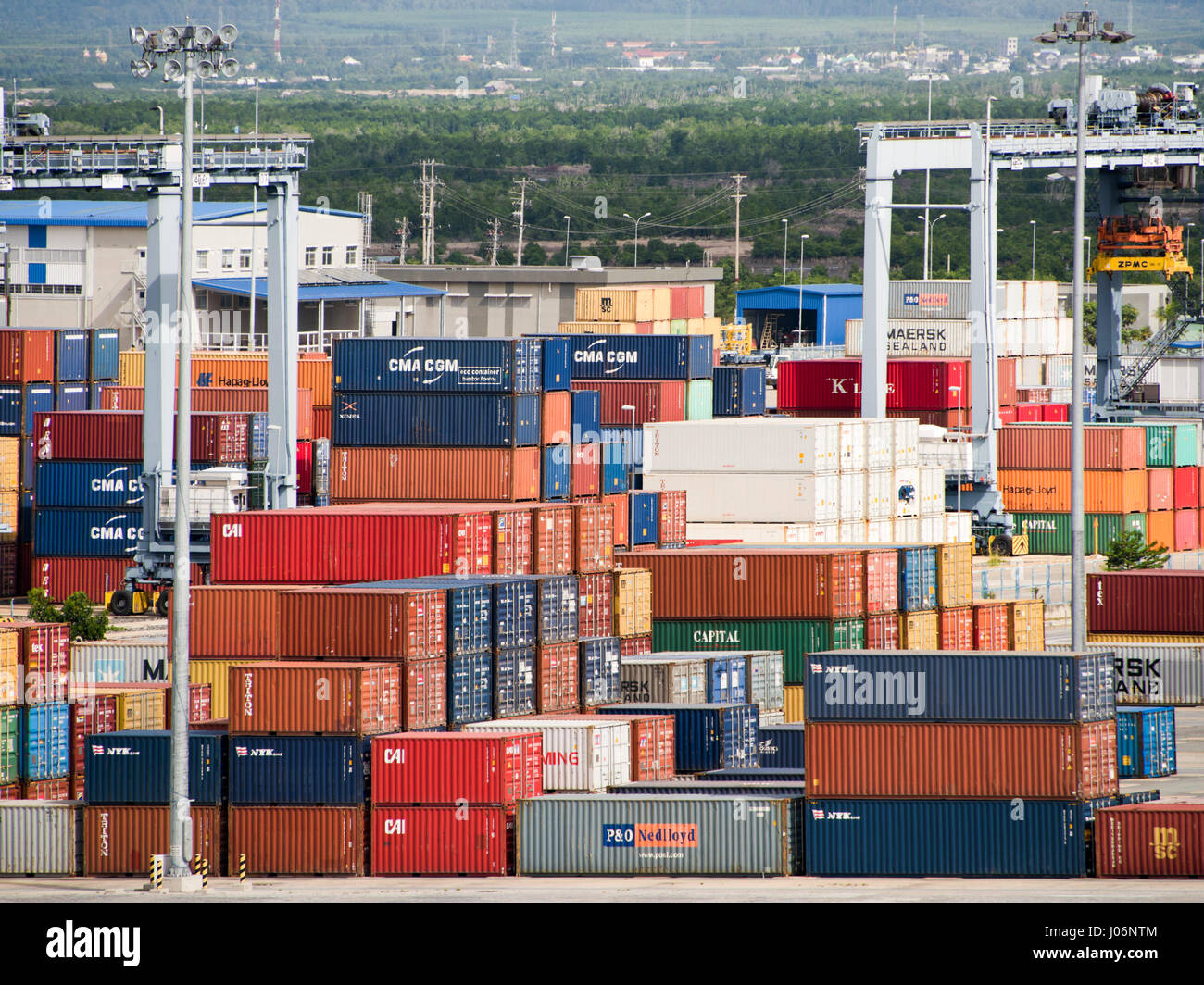 Horizontal view of brightly coloured containers stacked high at a port ...