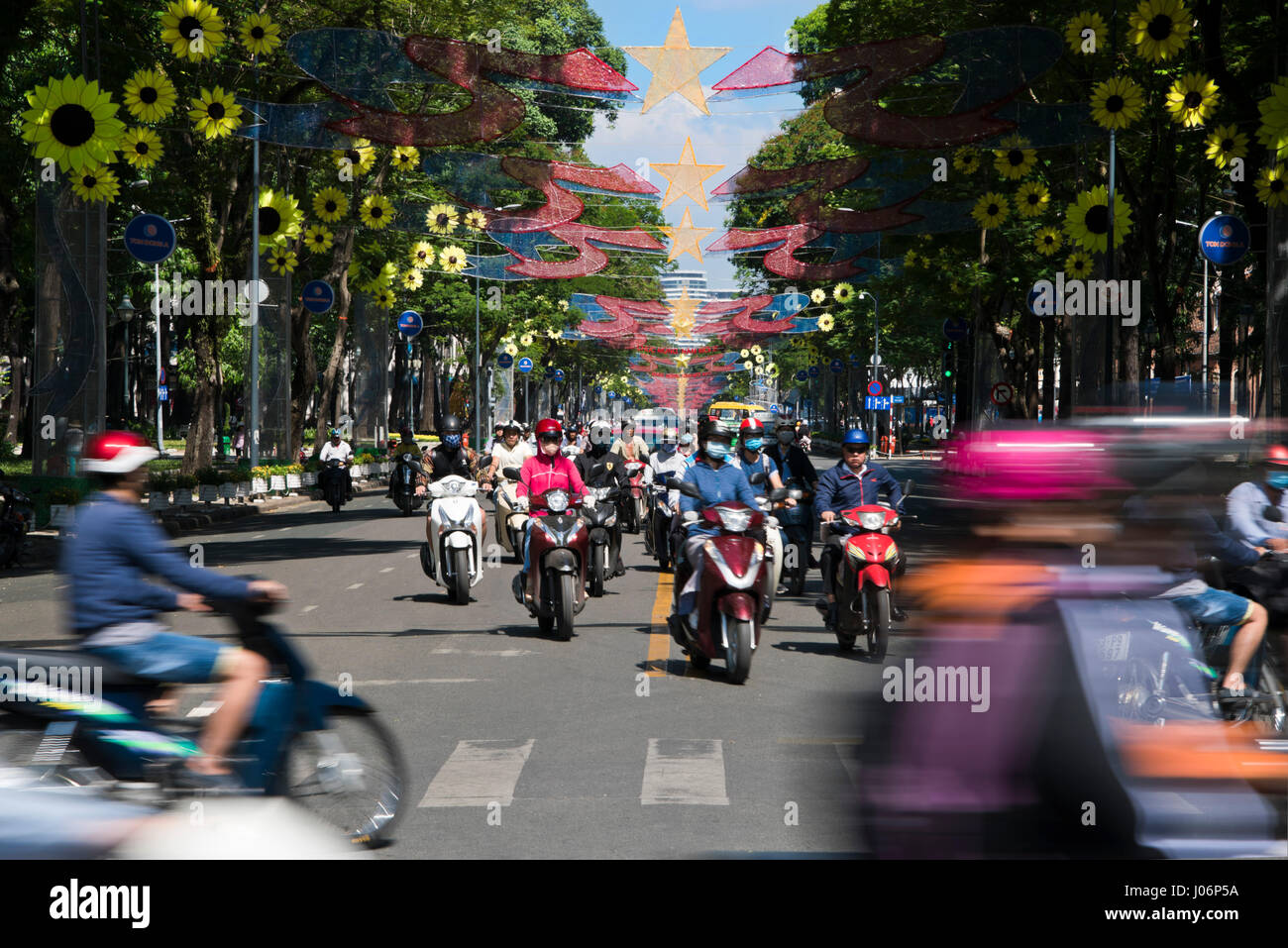 Horizontal view of people riding mopeds in Vietnam Stock Photo - Alamy