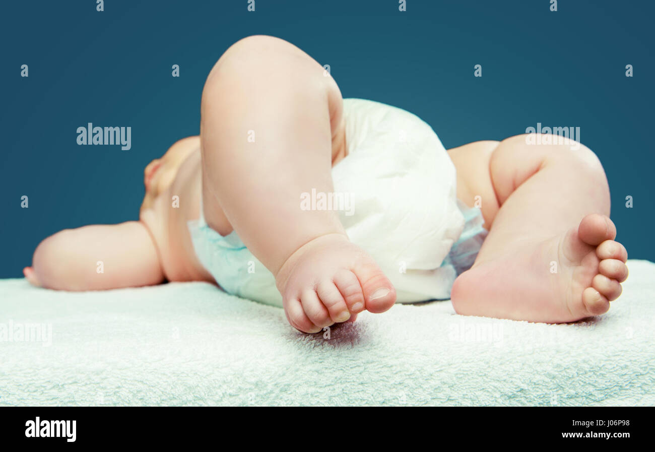 baby wearing diapers, against blue studio background Stock Photo - Alamy