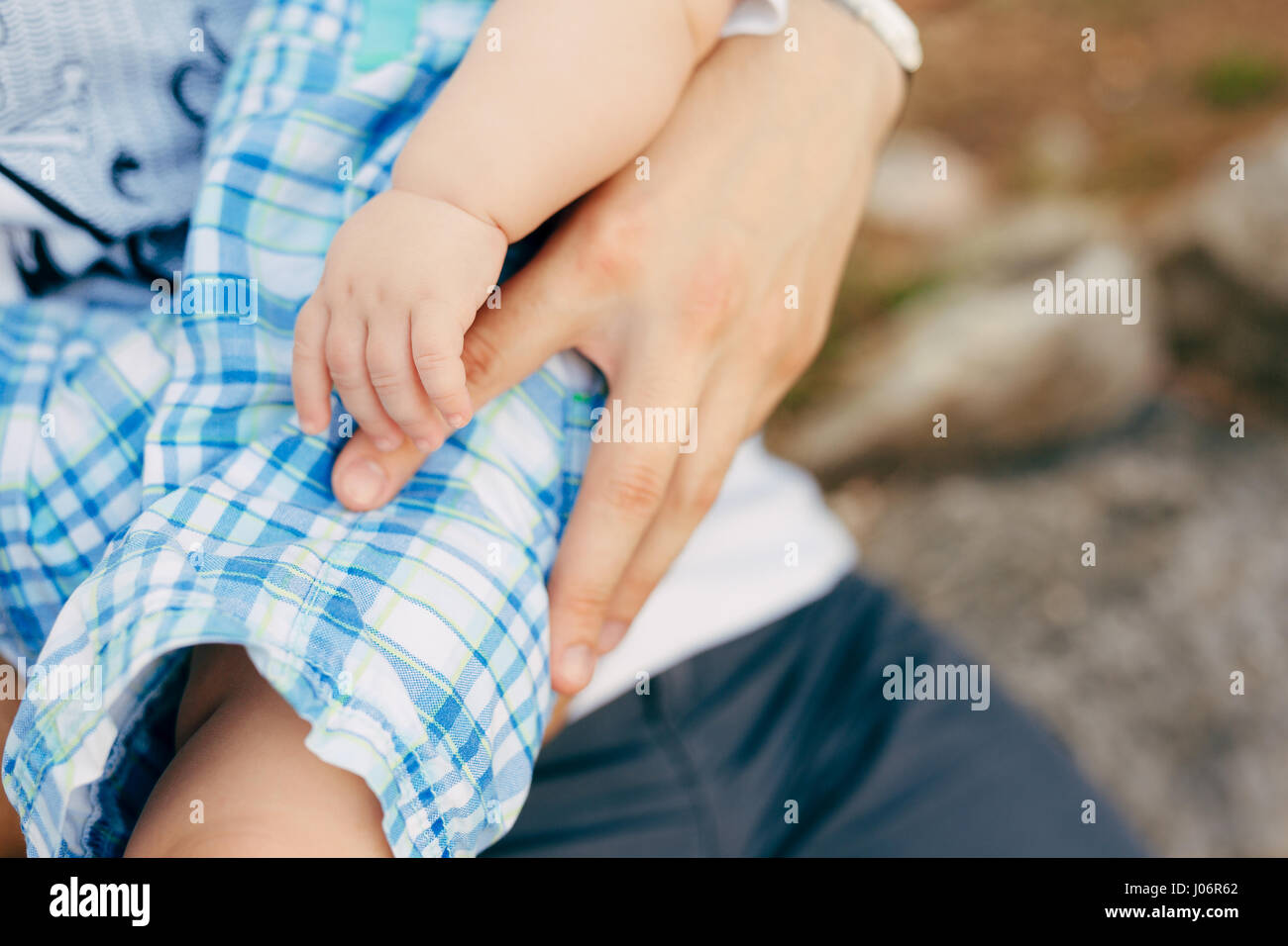 Parents hold the child in their arms. A little child with parents Stock ...