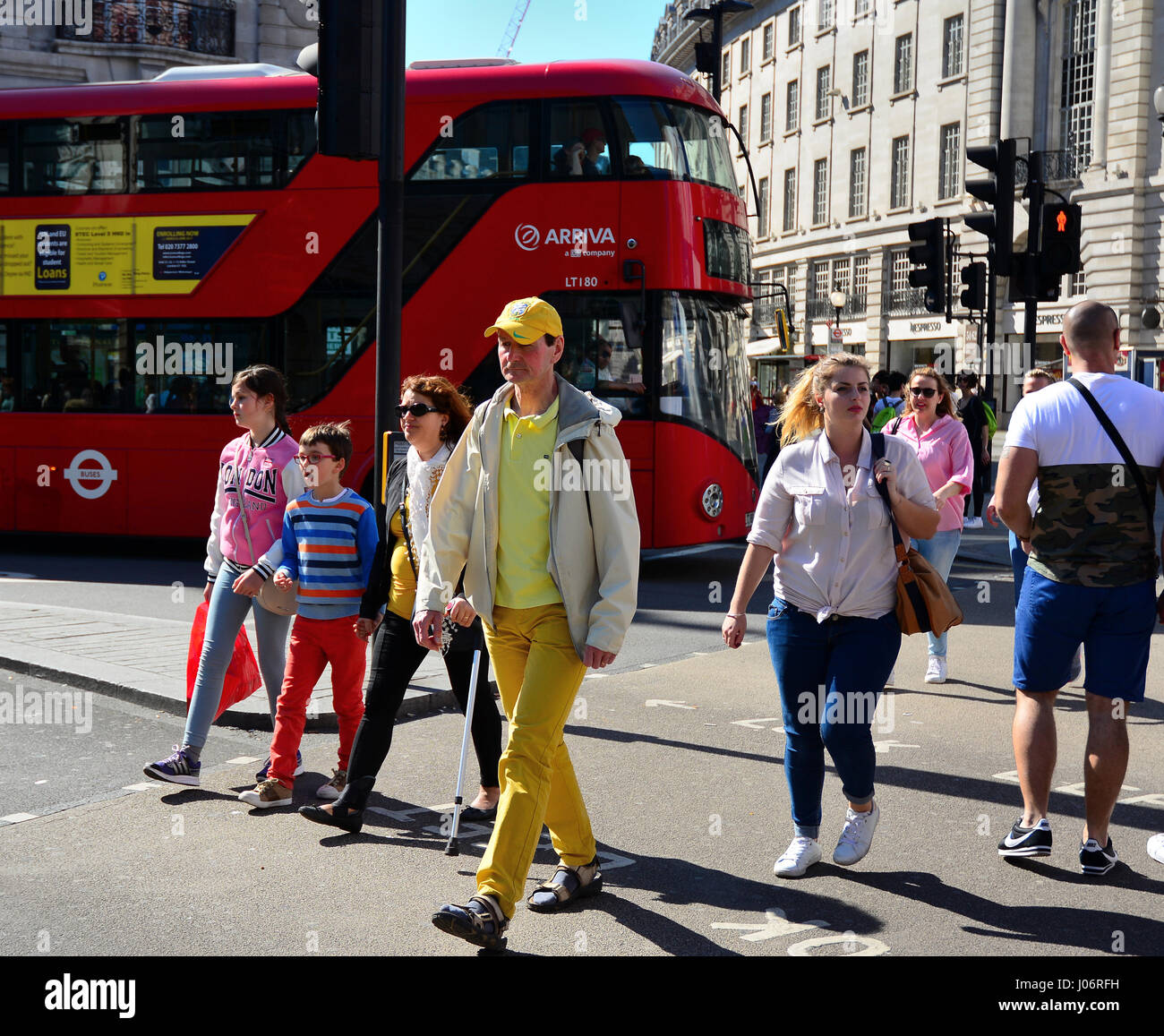 man in wearing yellow clothes and yellow cap crossing road in London ...