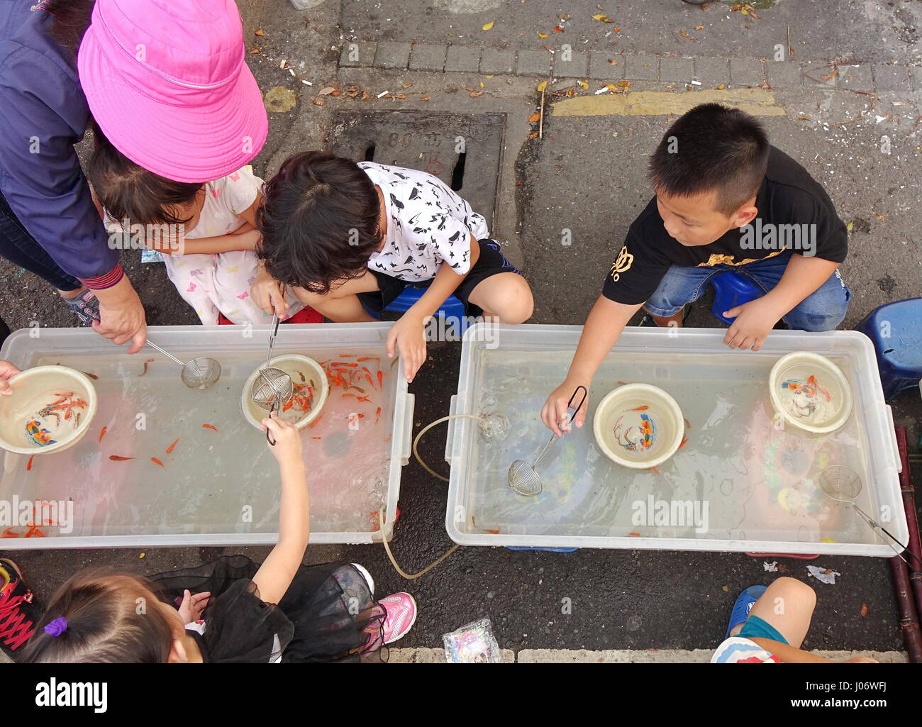 KAOHSIUNG, TAIWAN -- OCTOBER 15, 2016: Young children catch small ...