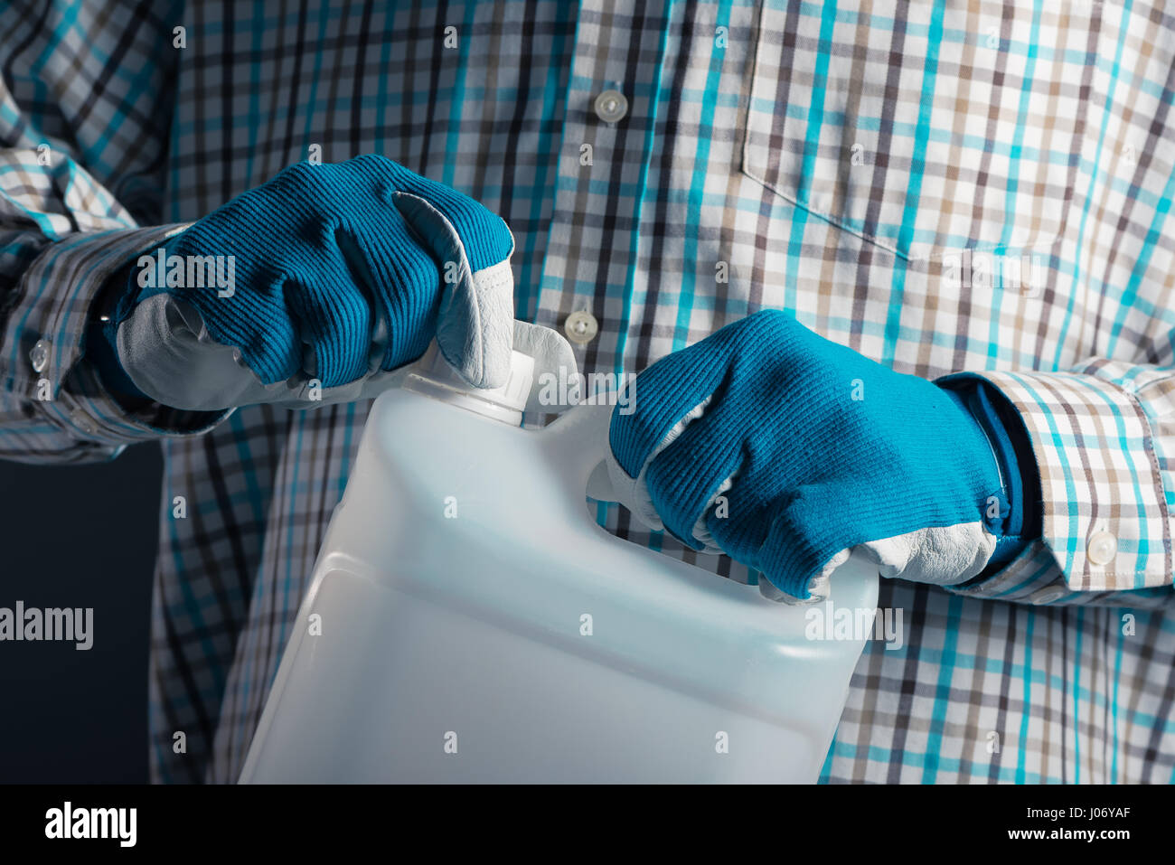 Unrecognizable male farmer with unlabeled plastic tank canister ...