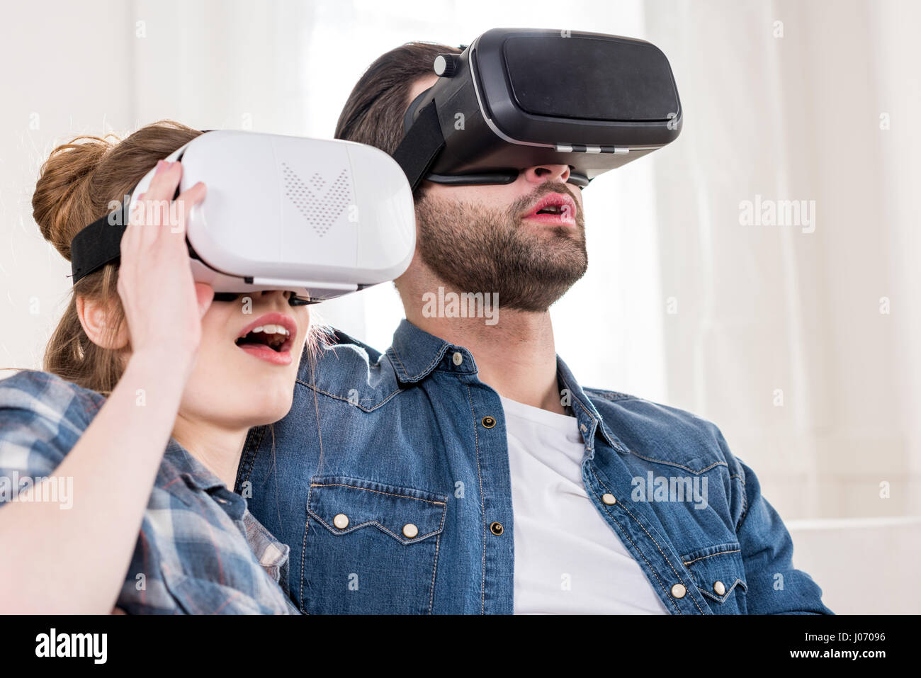 Portrait of young couple using virtual reality headsets Stock Photo - Alamy