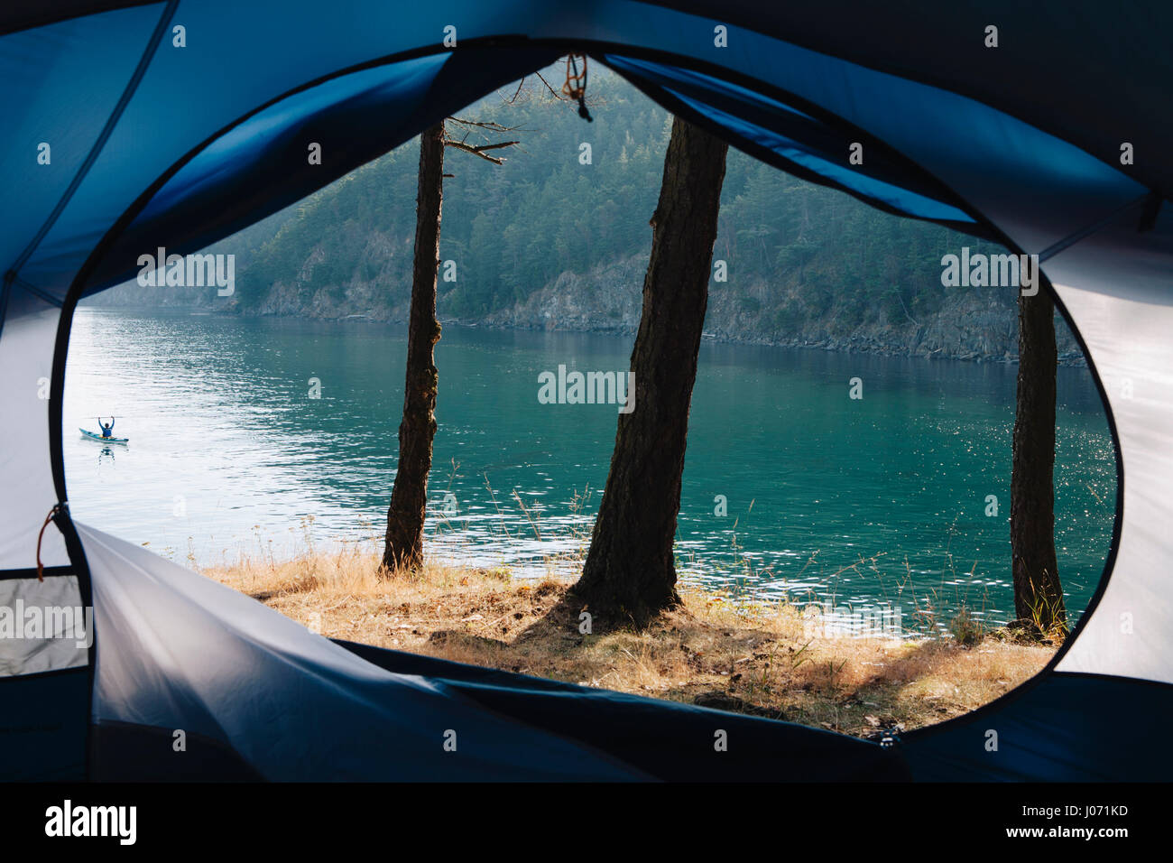 Man sea kayaking in the distance near San Juan Islands, Washington, USA ...