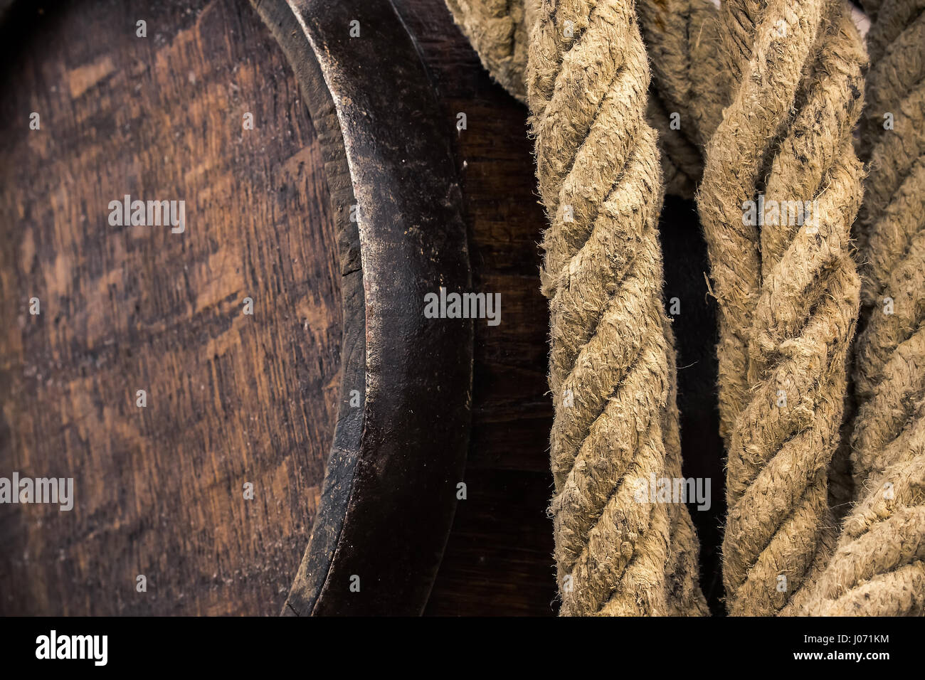 An old weathered barrel and a worn rope hanging side by side Stock ...