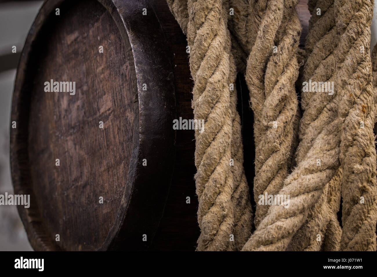 An old weathered barrel and a worn rope hanging side by side Stock ...