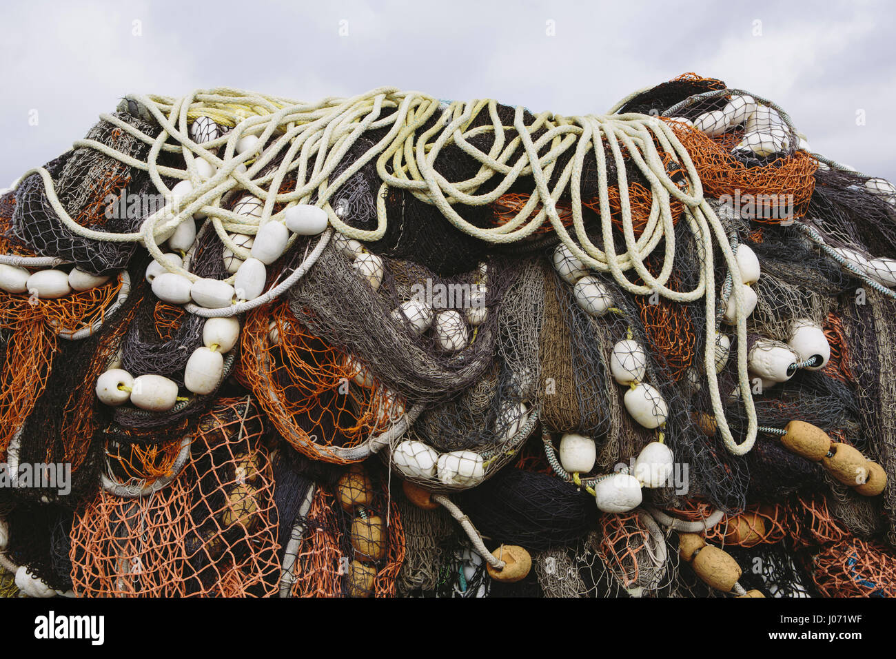 Close up of a pile of tangled up commercial fishing nets with floats ...