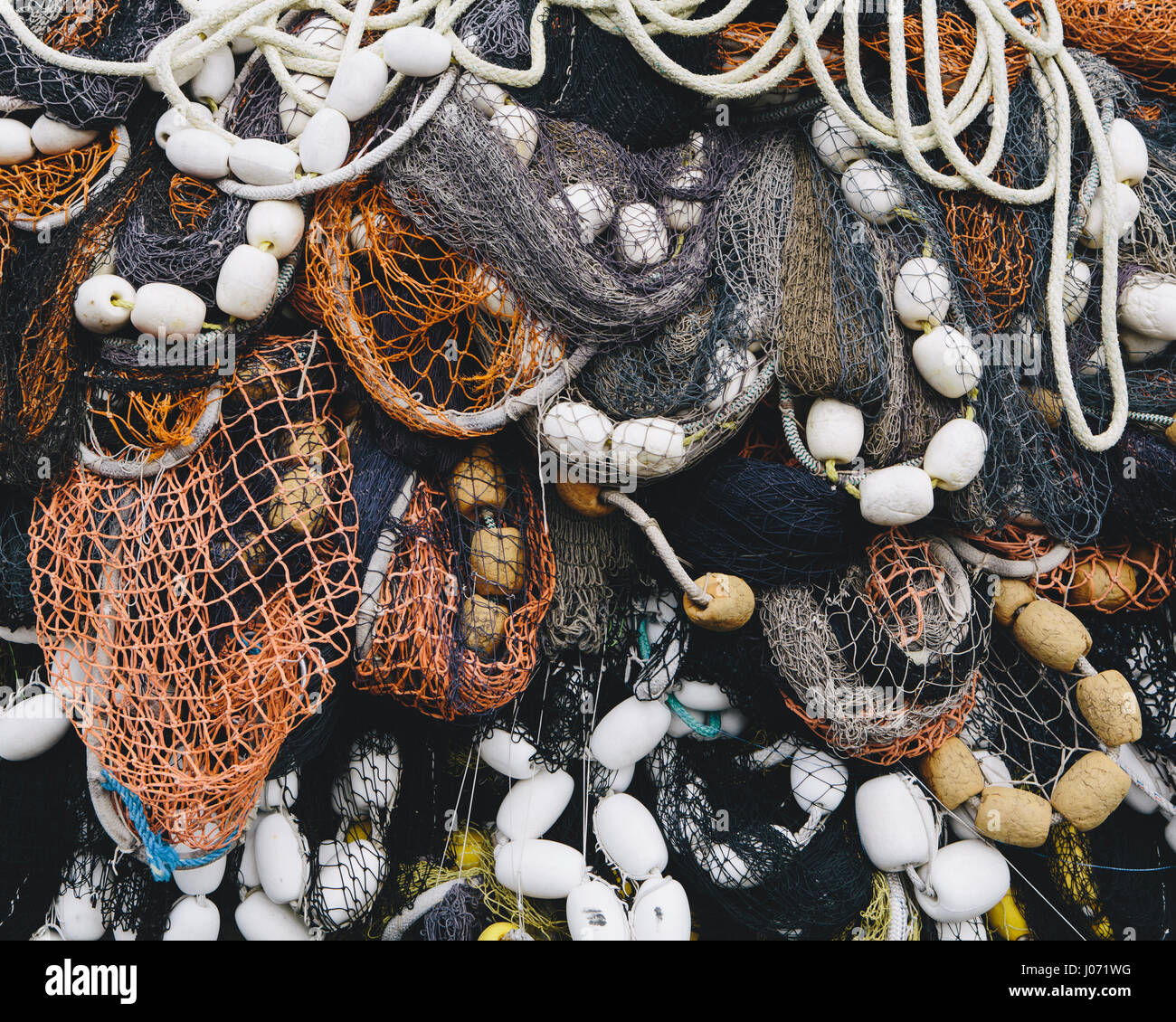 Close up of a pile of tangled up commercial fishing nets with floats ...