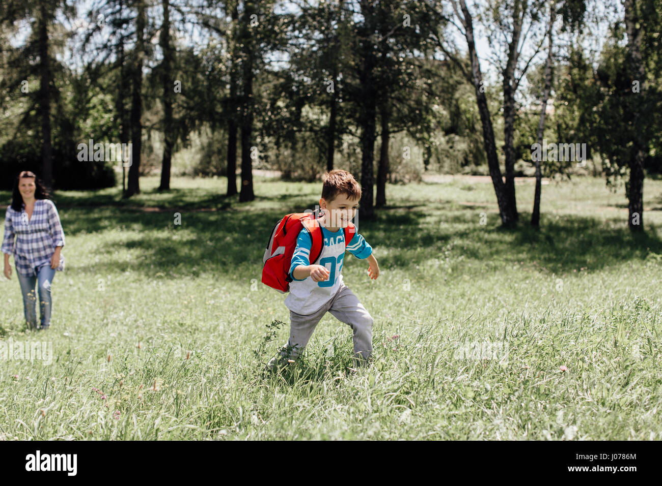 Happy schoolboy on his way to school running away from his mother Stock ...