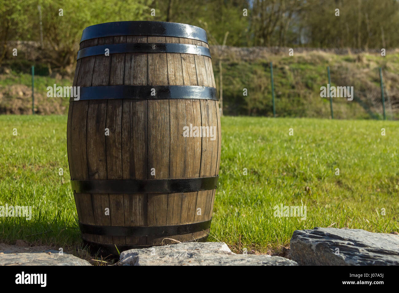 Barrel on some natural stones with a green grass and nice wood as the ...