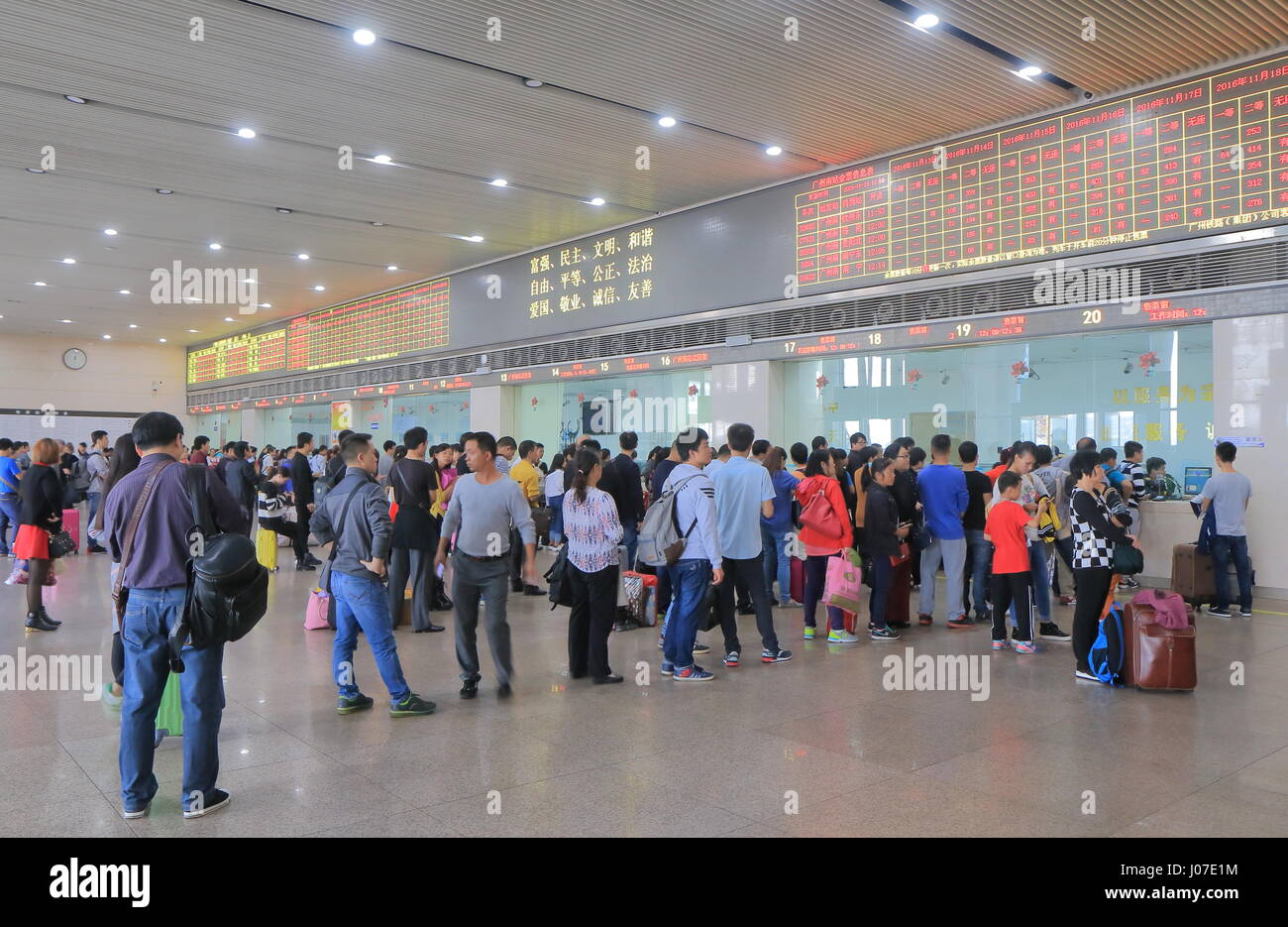 People queue to buy train tickets at Guangzhou South train station in ...