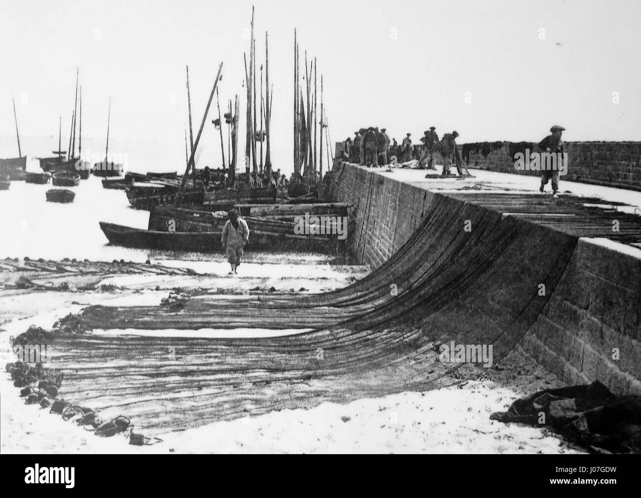 This image captures a scene of fishing preparations around 1900, with ...