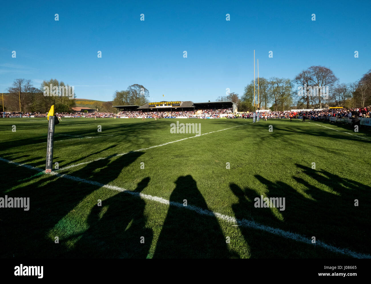 Spectators cast long shadows across the field of play during the ...