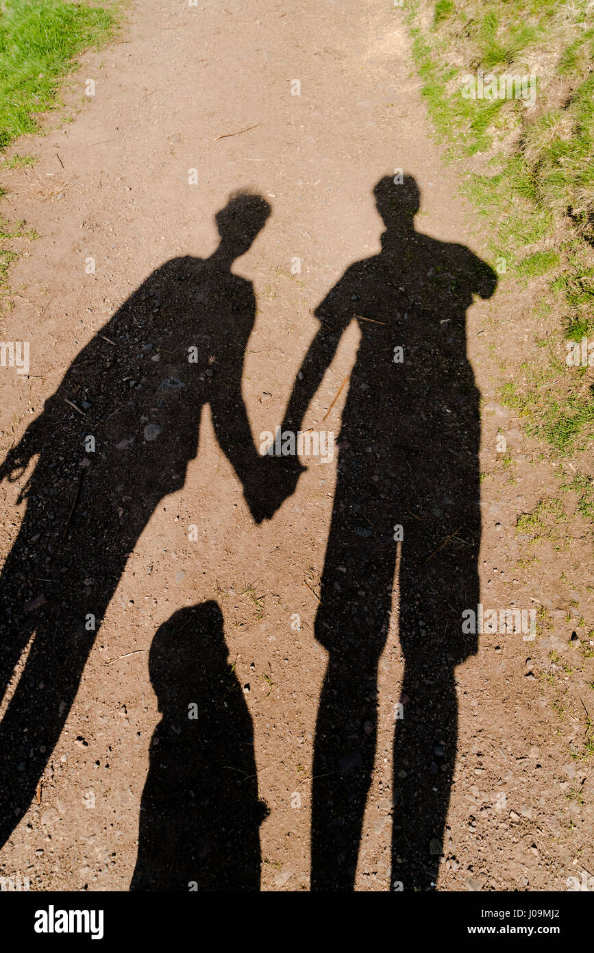 Shadows of two people holding hands and a dog walking outdoors Stock ...