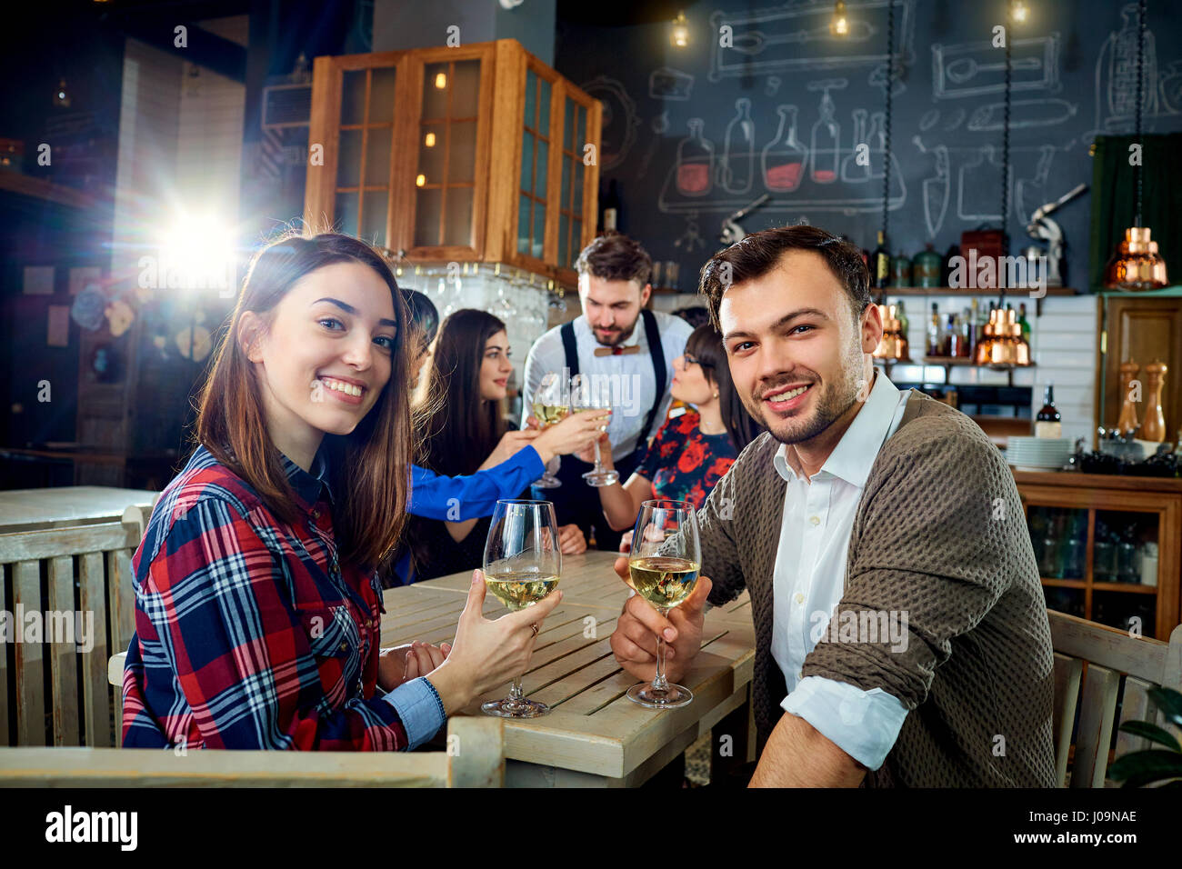 Meeting friends at the bar restaurant. A couple of men and girl Stock ...