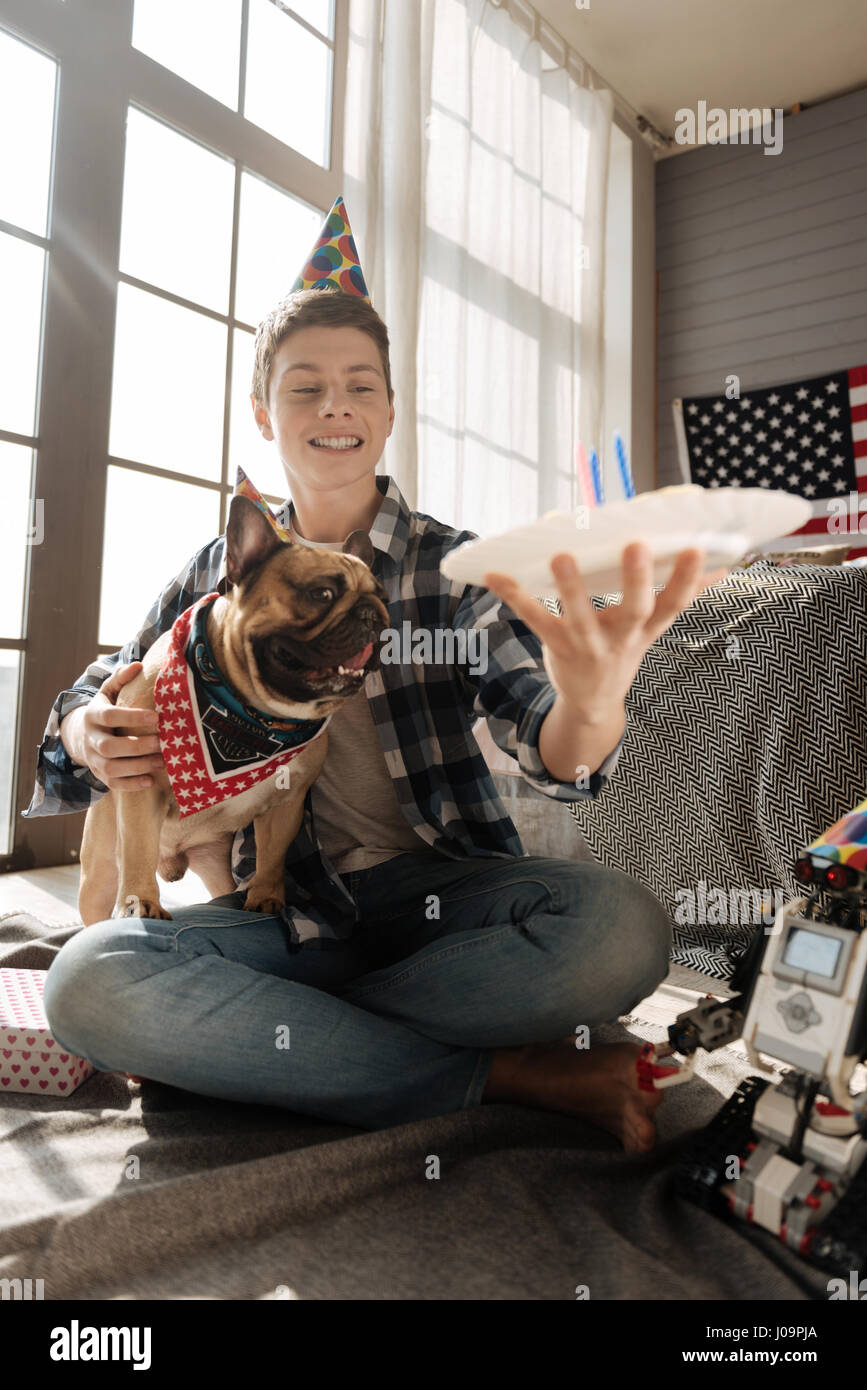 Enjoy this day. Joyful pet wearing paper cap keeping mouth opened ...