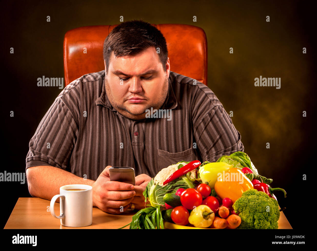 Diet fat man eating healthy food and orders by phone Stock Photo - Alamy
