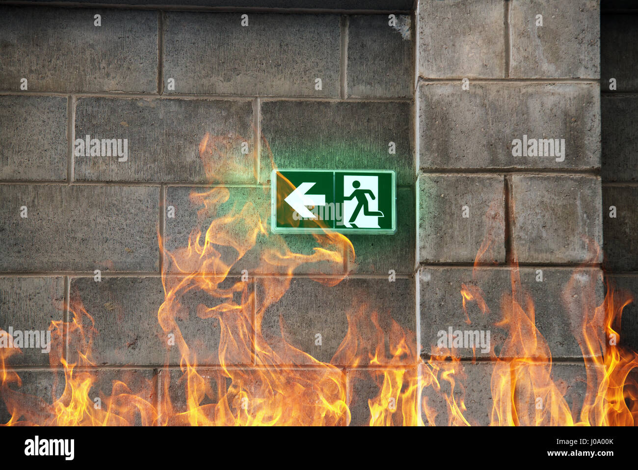 Emergency Fire Exit on the stone wall with fire flames Stock Photo - Alamy