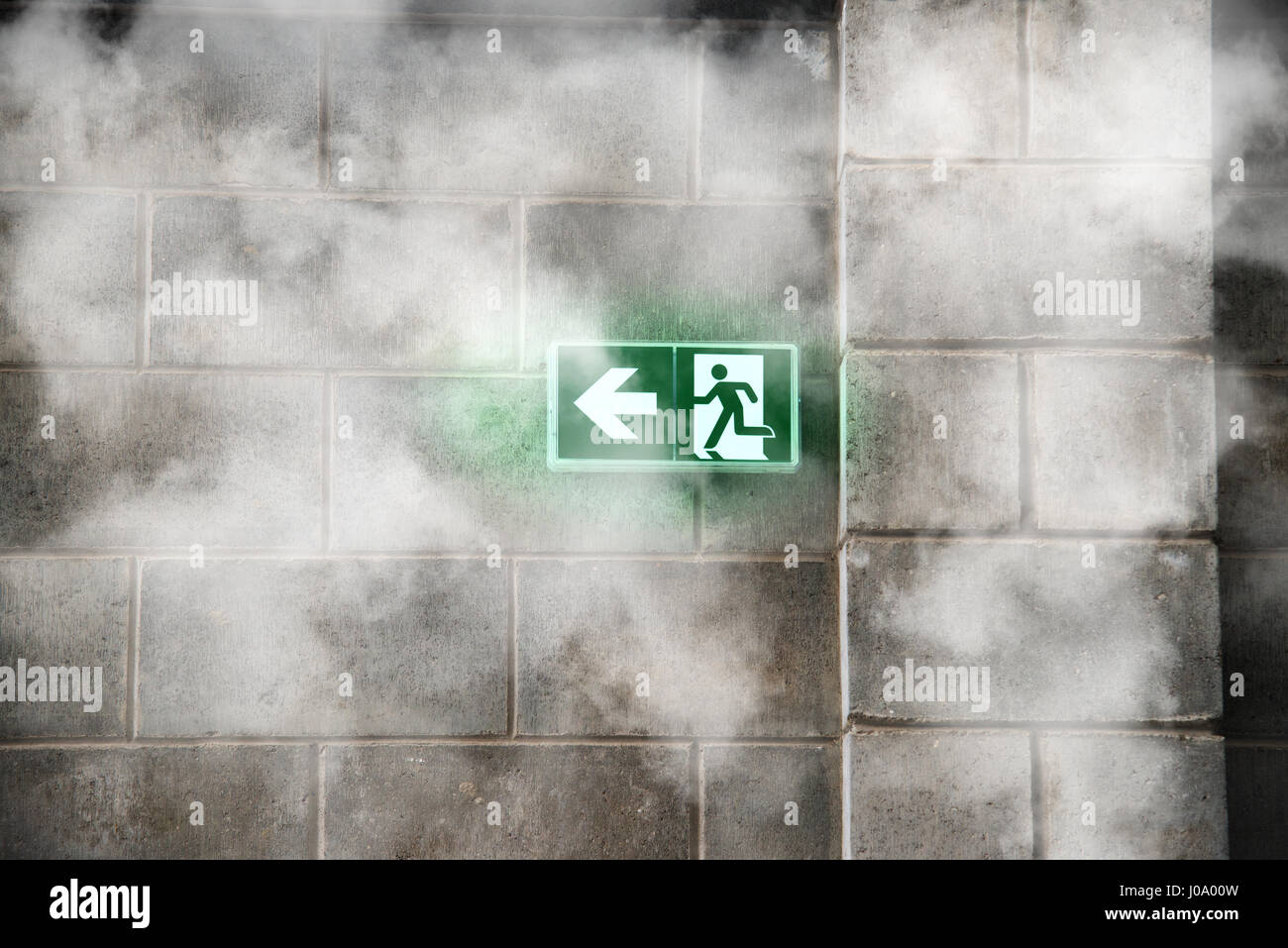 Emergency Fire Exit on the stone wall with fire smoke Stock Photo - Alamy