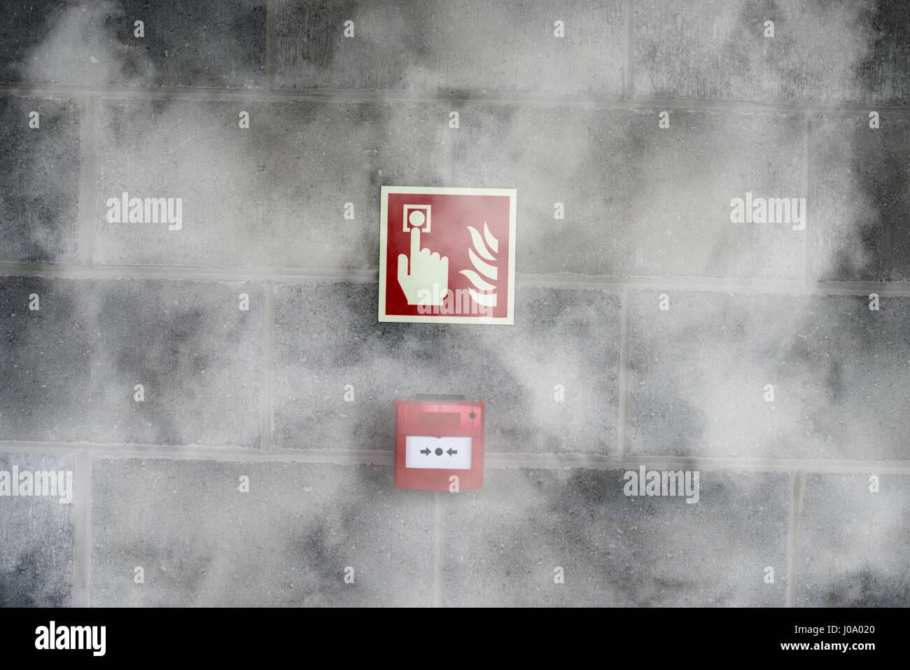 Emergency Fire Exit on the stone wall with fire smoke Stock Photo - Alamy