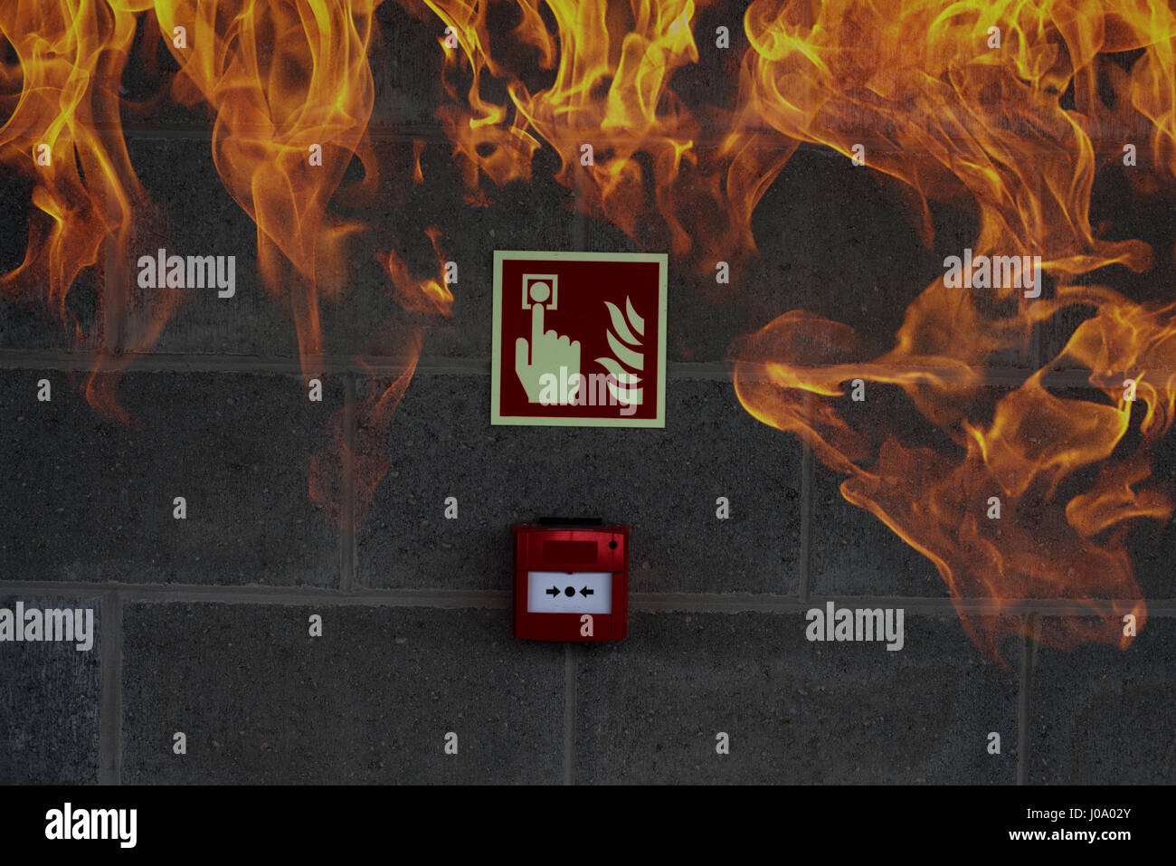 Emergency Fire Exit on the stone wall with fire flames Stock Photo - Alamy